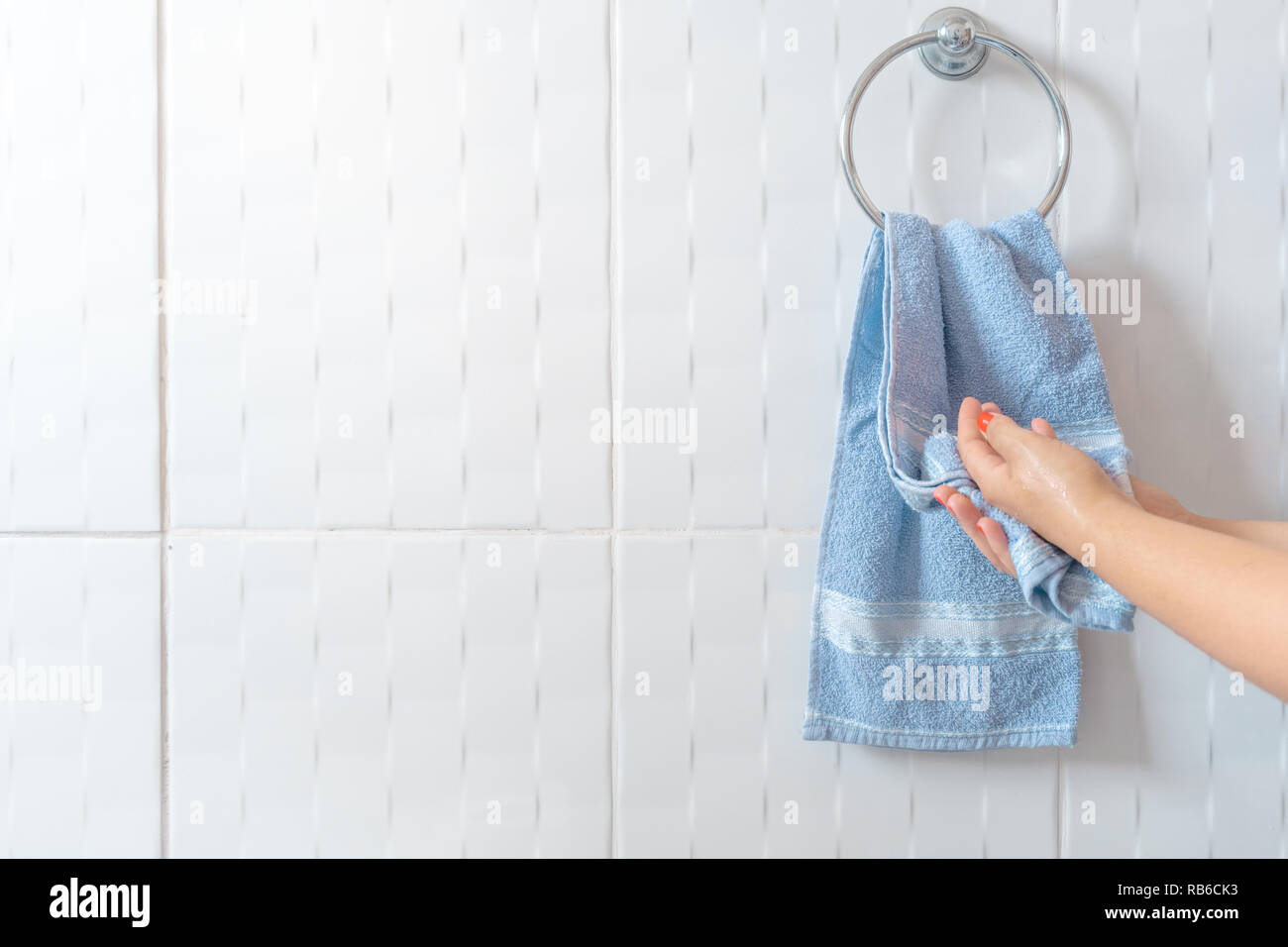Woman drying hands with blue towel Stock Photo - Alamy