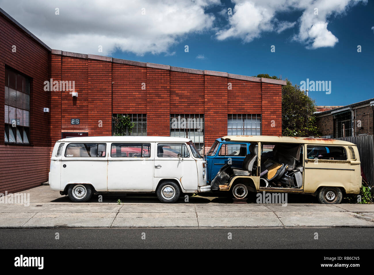 Two wrecked white Volkswagen vans in front of a brick building Stock ...