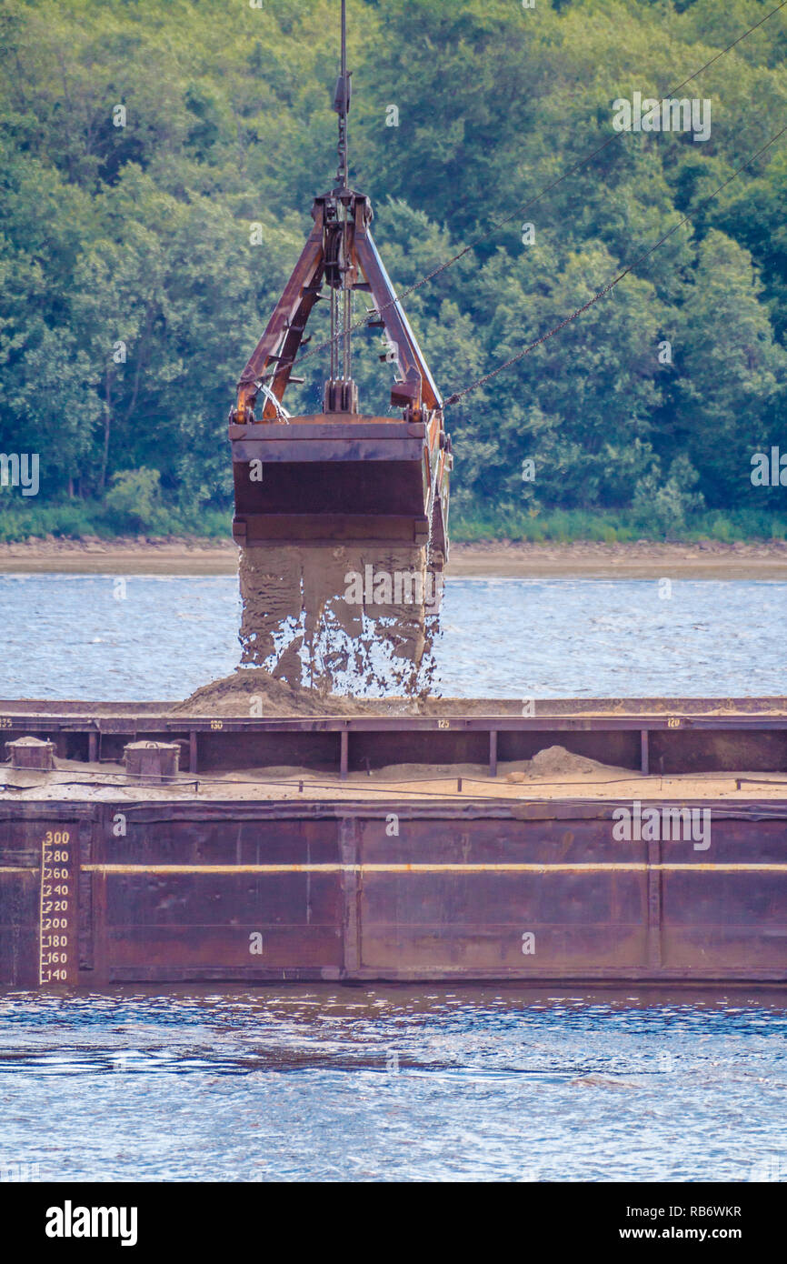 crane on the ship produces sand on the river on a summer day Stock ...