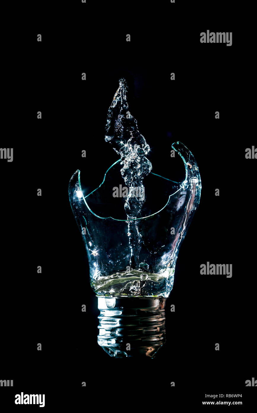 Creative broken light bulb with water fountain on isolated black ...
