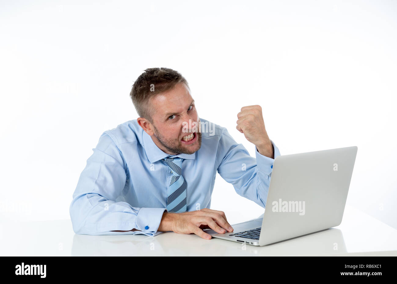 Stressed entrepreneur businessman with laptop computer at office desk ...