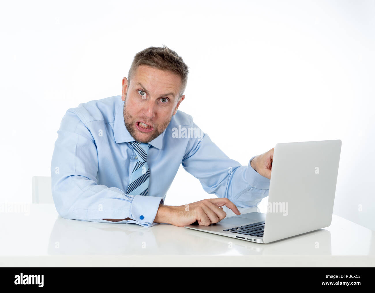 Stressed entrepreneur businessman with laptop computer at office desk ...