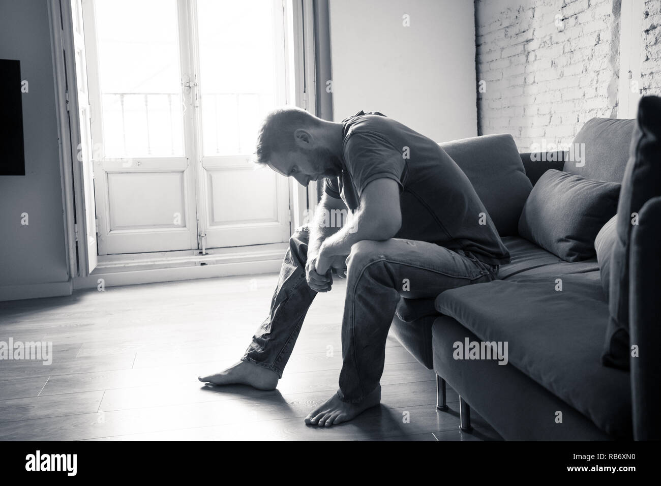 Unhappy depressed caucasian male sitting crying and lying in living ...