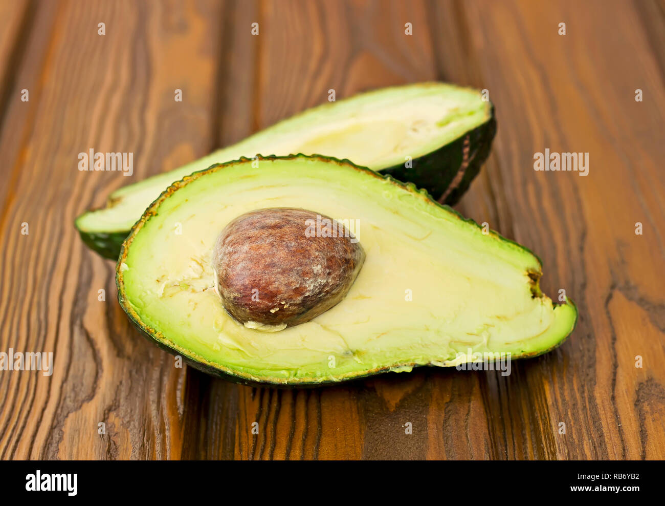 Avocado, cut in half and the seed of avocado Stock Photo - Alamy