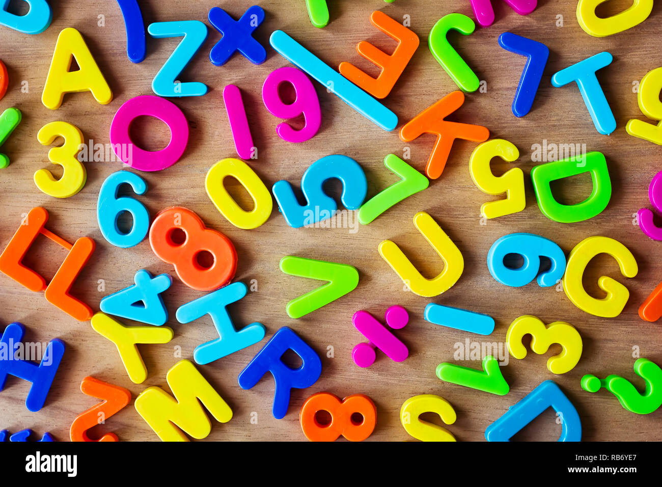 Colored letters and numbers of plastic on wooden table Stock Photo - Alamy