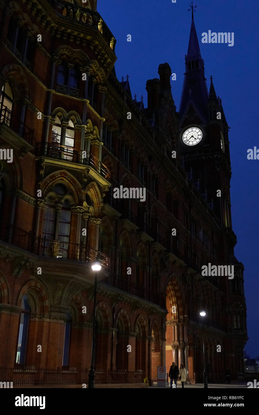 Clock tower and lighted entrance to the victorian brick gothic building ...