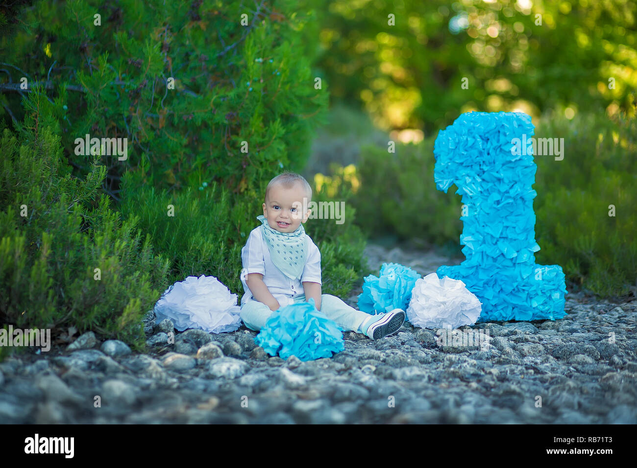 little baby boy sitting close to number one birthday number blue color ...