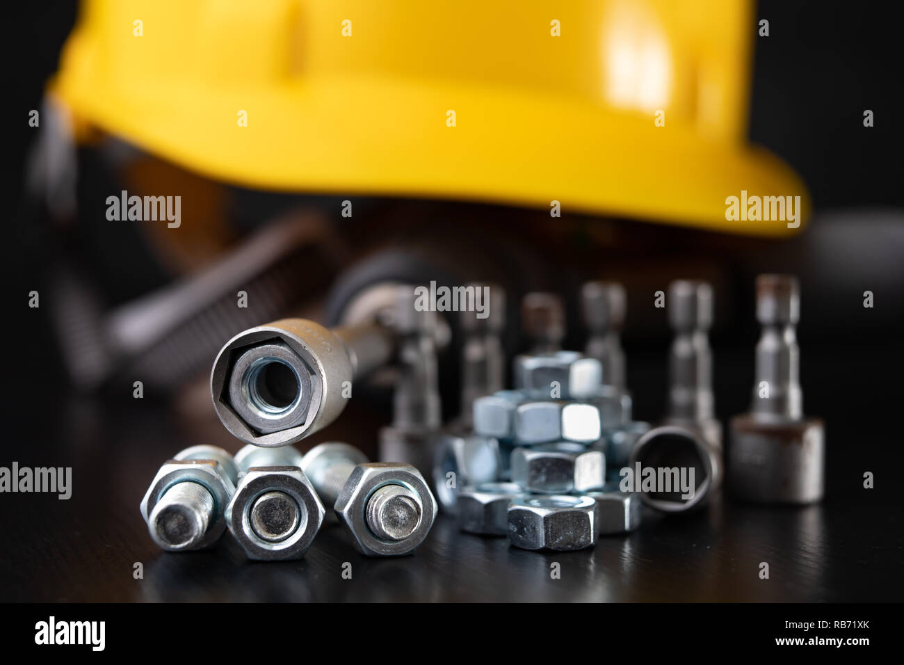 Screws, nuts and keys on a workshop table. Tools and accessories for ...