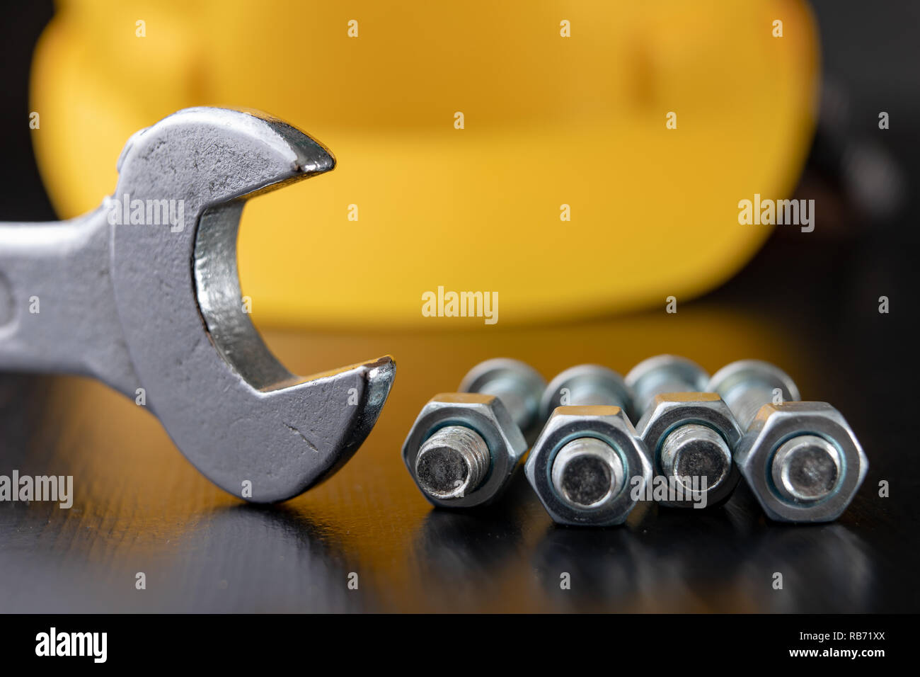 Screws, nuts and keys on a workshop table. Tools and accessories for ...