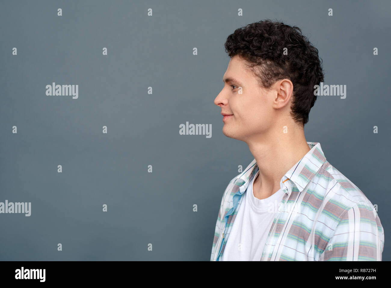 Young guy isolated on gray wall free style standing looking forward ...