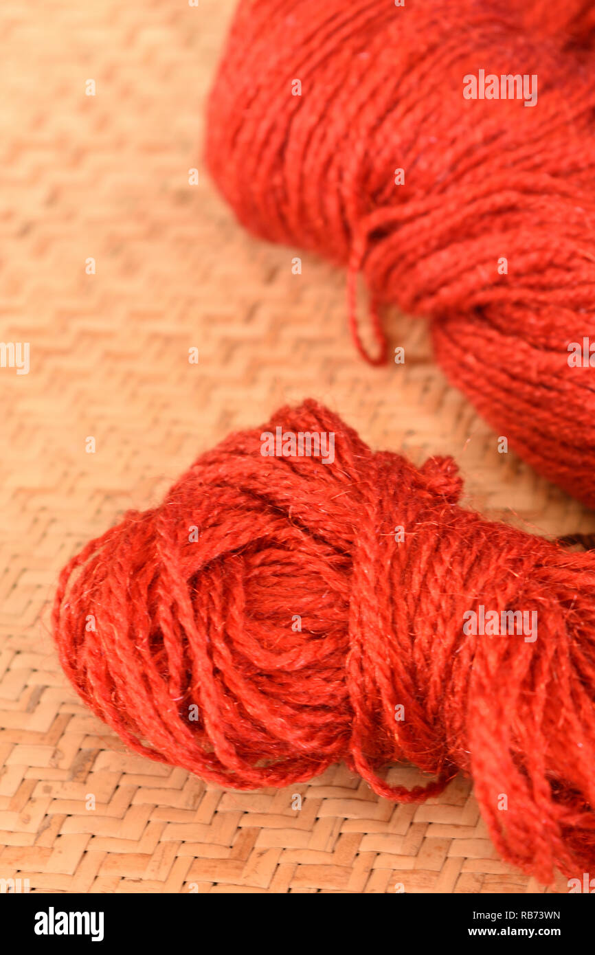 Red round yarn ball isolated in brown background Stock Photo - Alamy