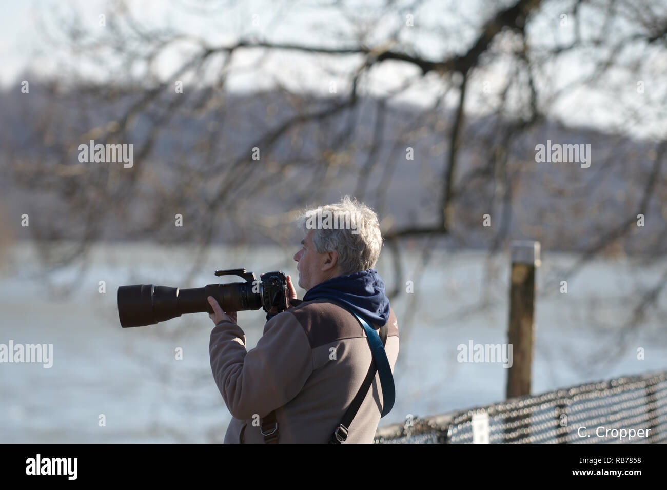 Middle age with gray hair man holding camera with zoom len Stock Photo ...