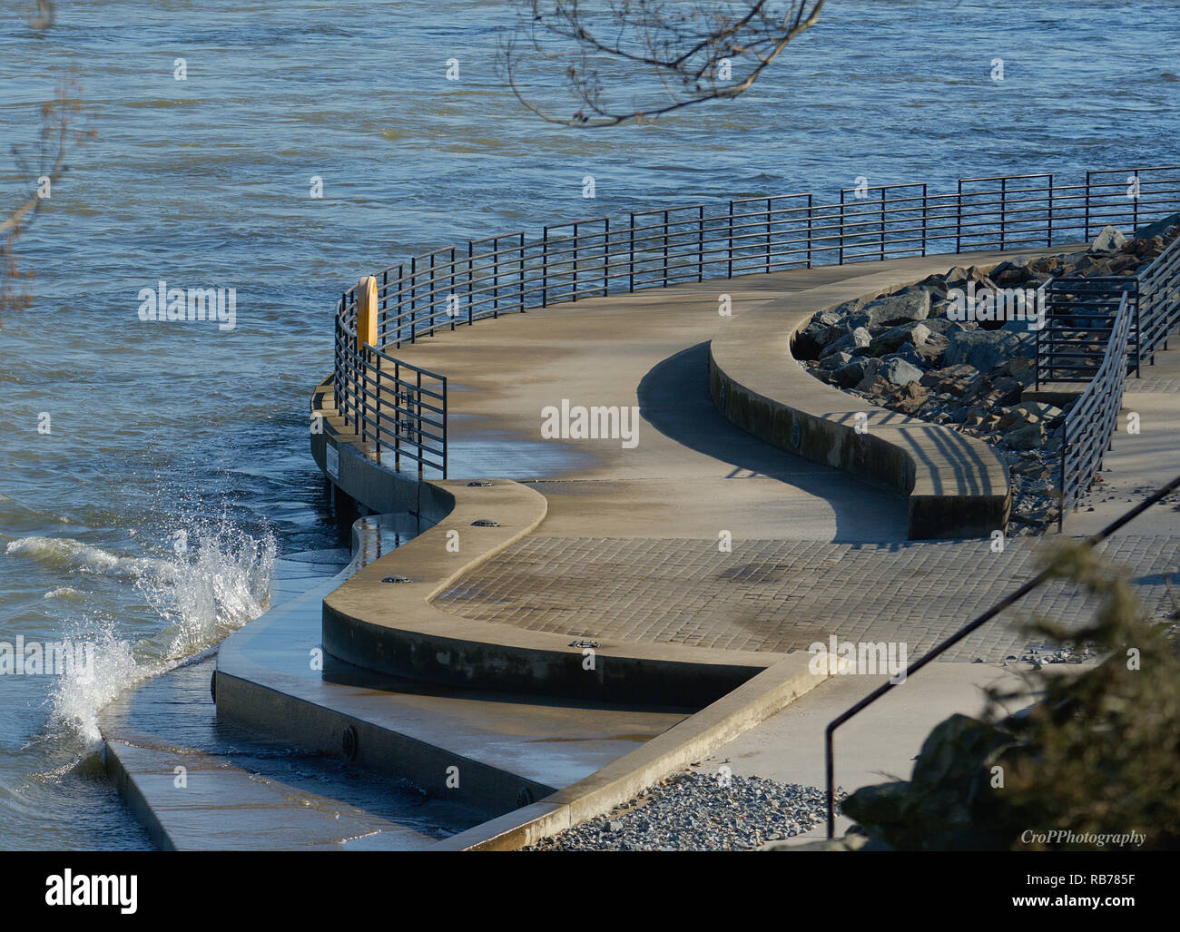 Curved concrete walkway with railing on river bank Stock Photo - Alamy