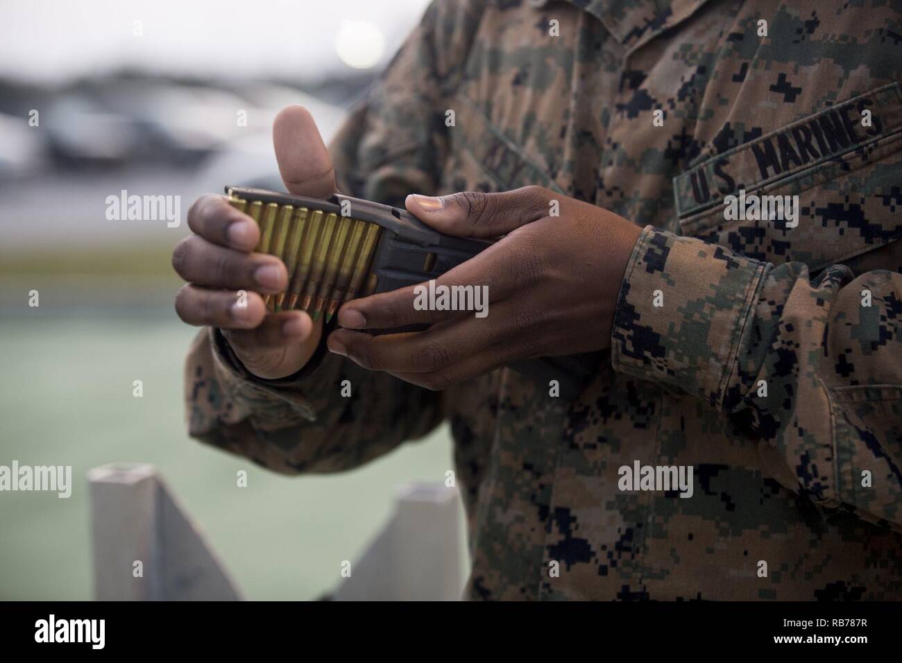 A U.S. Marine stationed in Okinawa loads his magazine for the ...