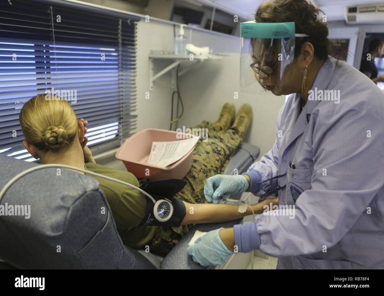 A Marine donates blood to the Armed Services Blood Program aboard ...
