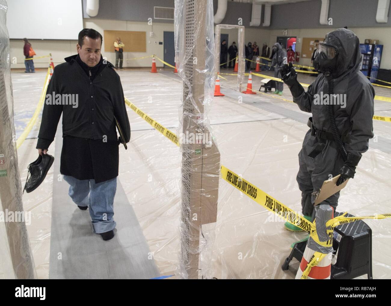 A volunteer walks through a radiation detector while a U.S. Solider ...