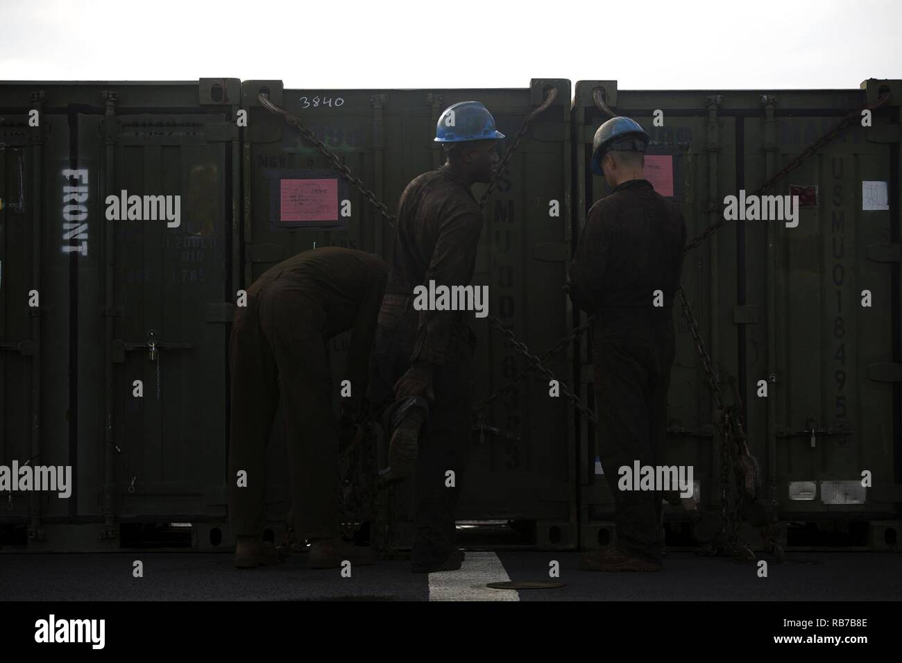 Combat cargo Marines lash containers to the deck of USS Carter Hall ...
