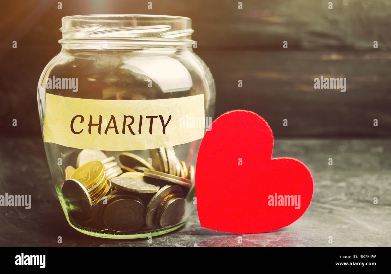 Glass jar with the words Charity and the heart. The concept of ...