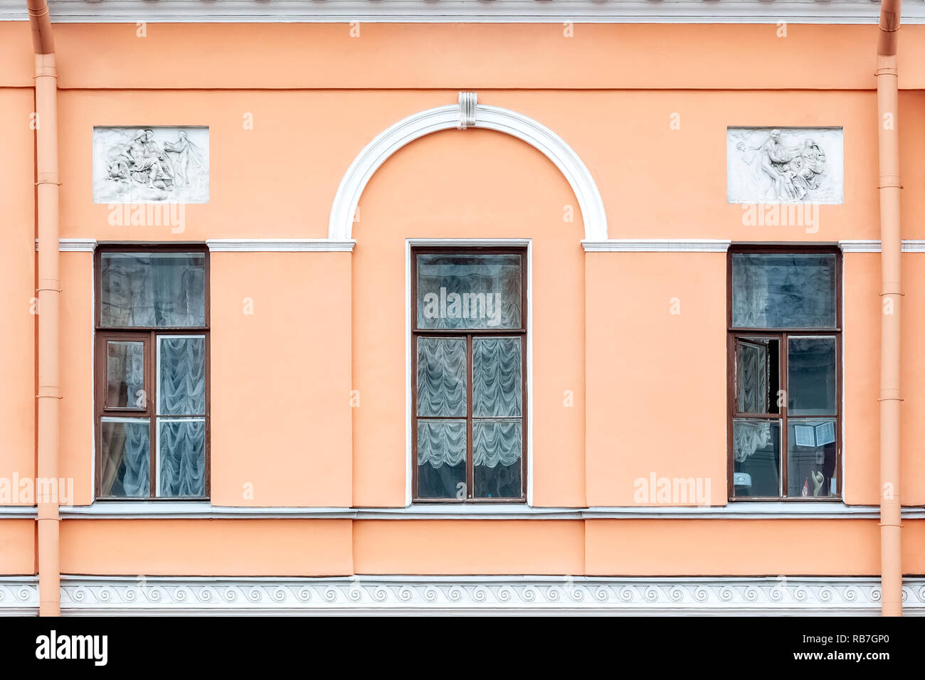 Three rectangular windows with an arch and a bas-relief on the ...