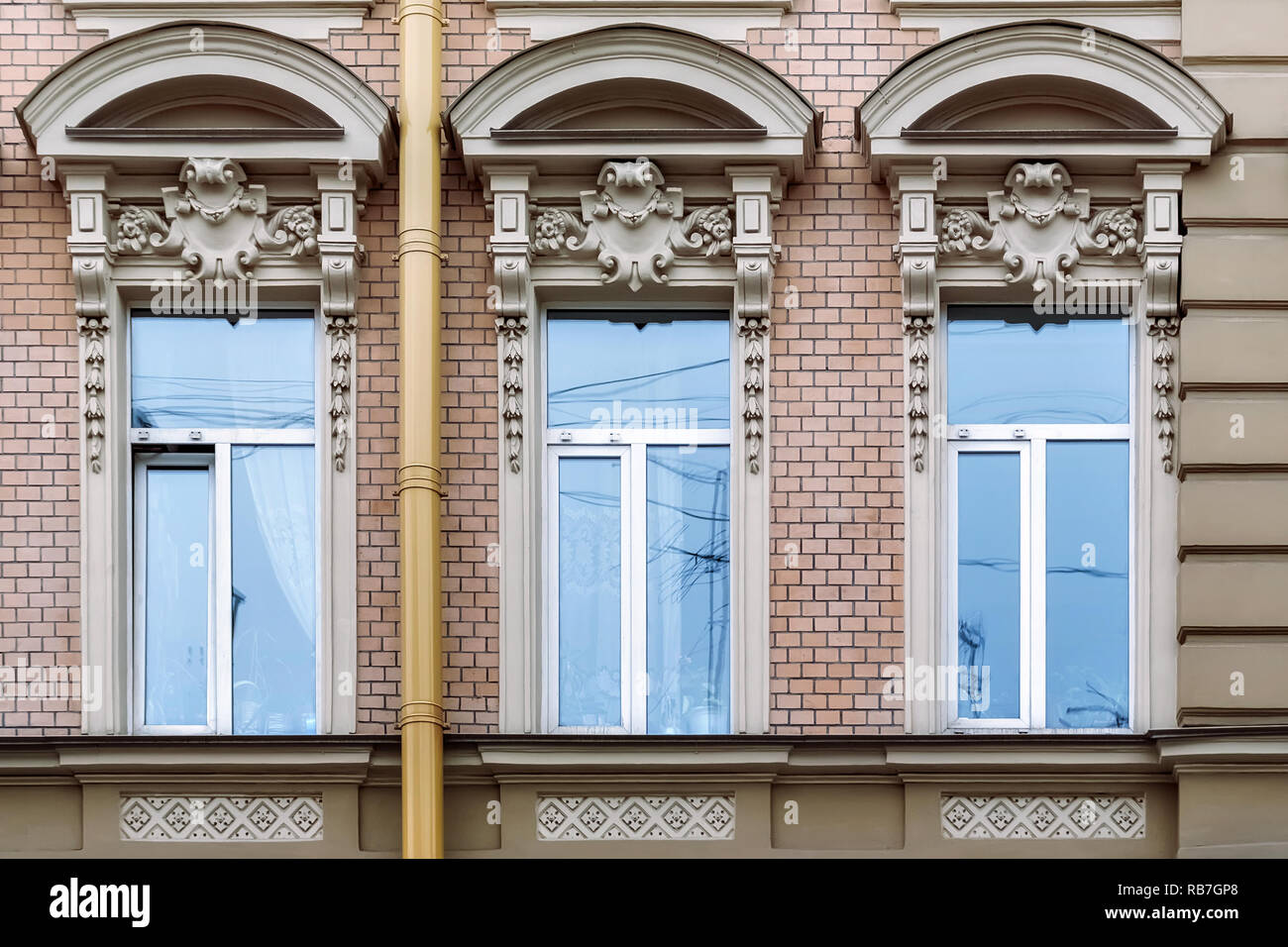 Three rectangular windows with an arch and a bas-relief on the ...