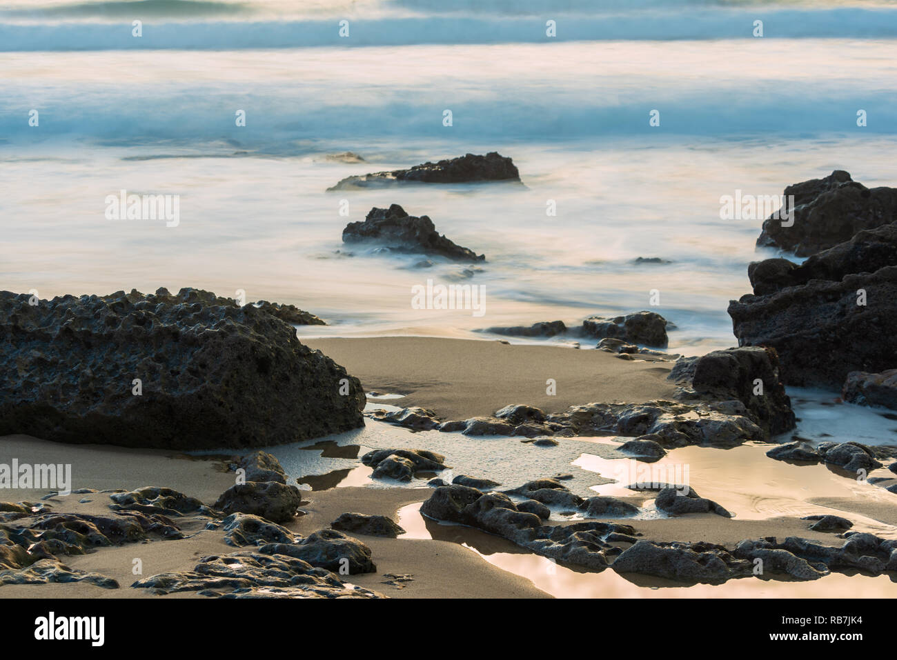 small beach with rocks and the ocean waves breaking on it Stock Photo ...