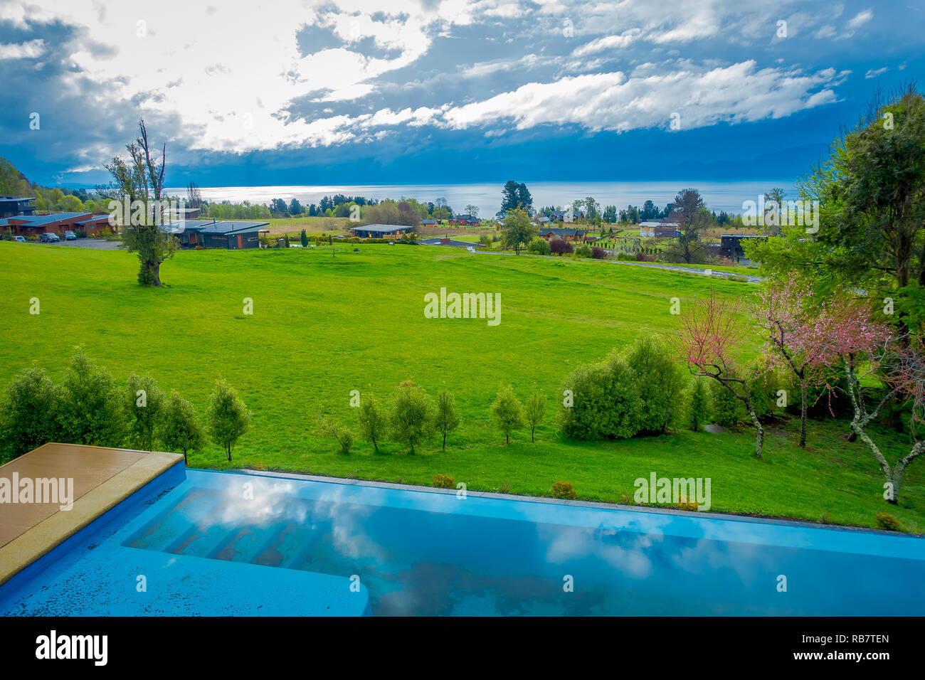 Beautiful outdoor view of infinity swimming pool with a gorgoues green ...