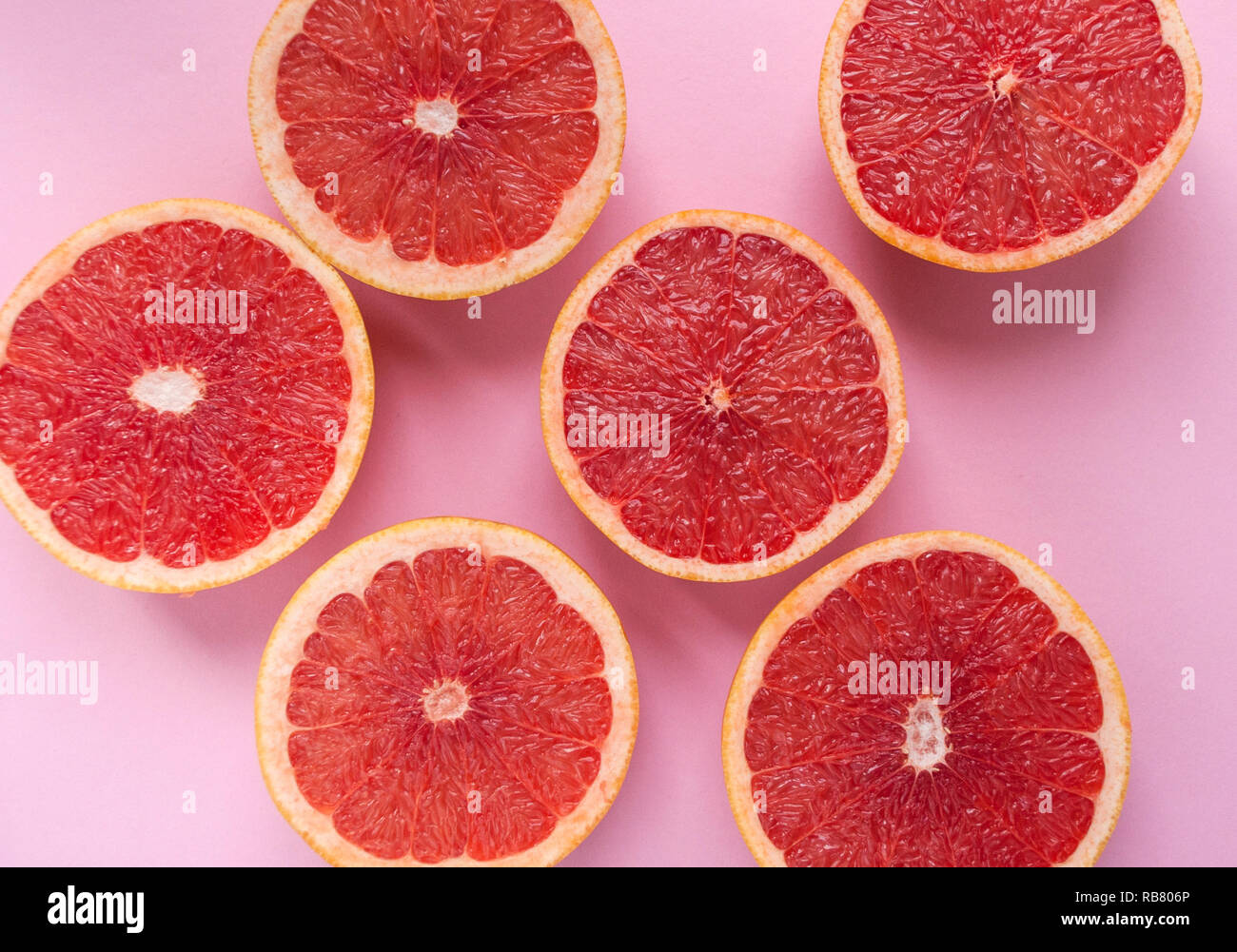 Halved grapefruit on pastel blue background Stock Photo - Alamy