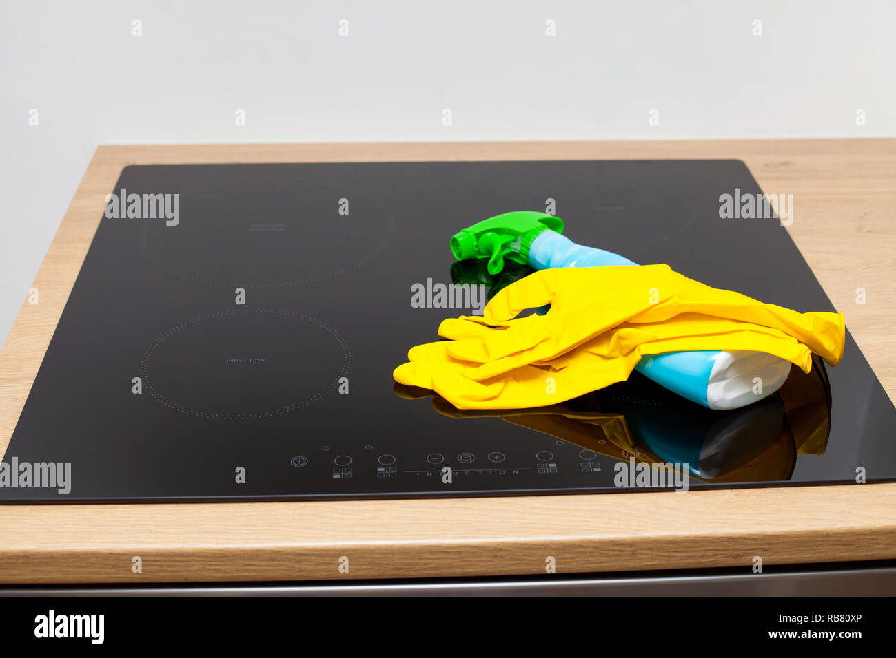 Induction hot plate and cleaning spray, yellow gloves. Housekeeping ...