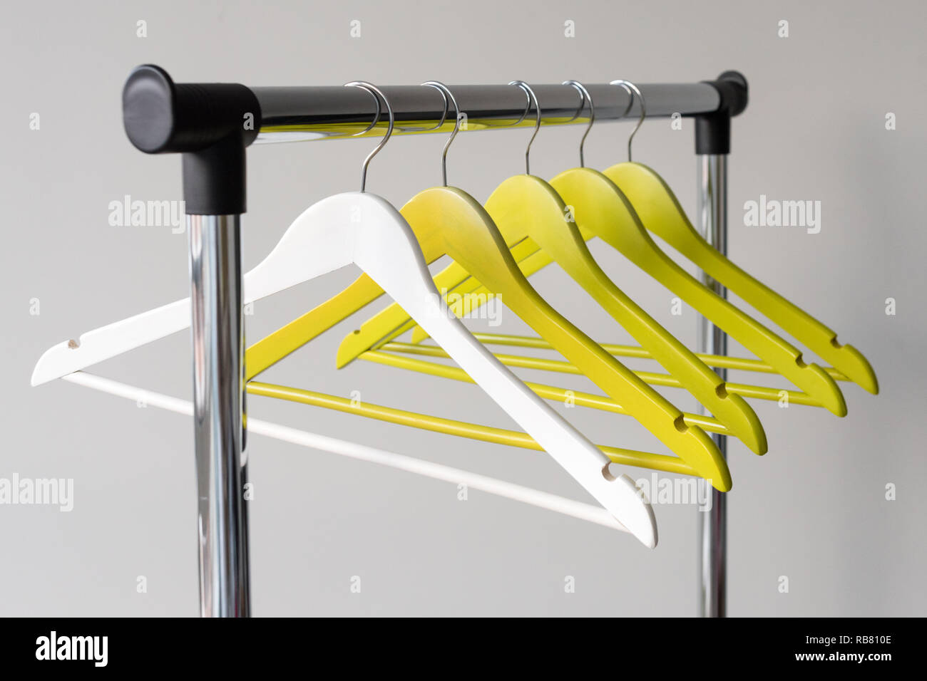 Empty clothes hangers on metal rail against grey background ...