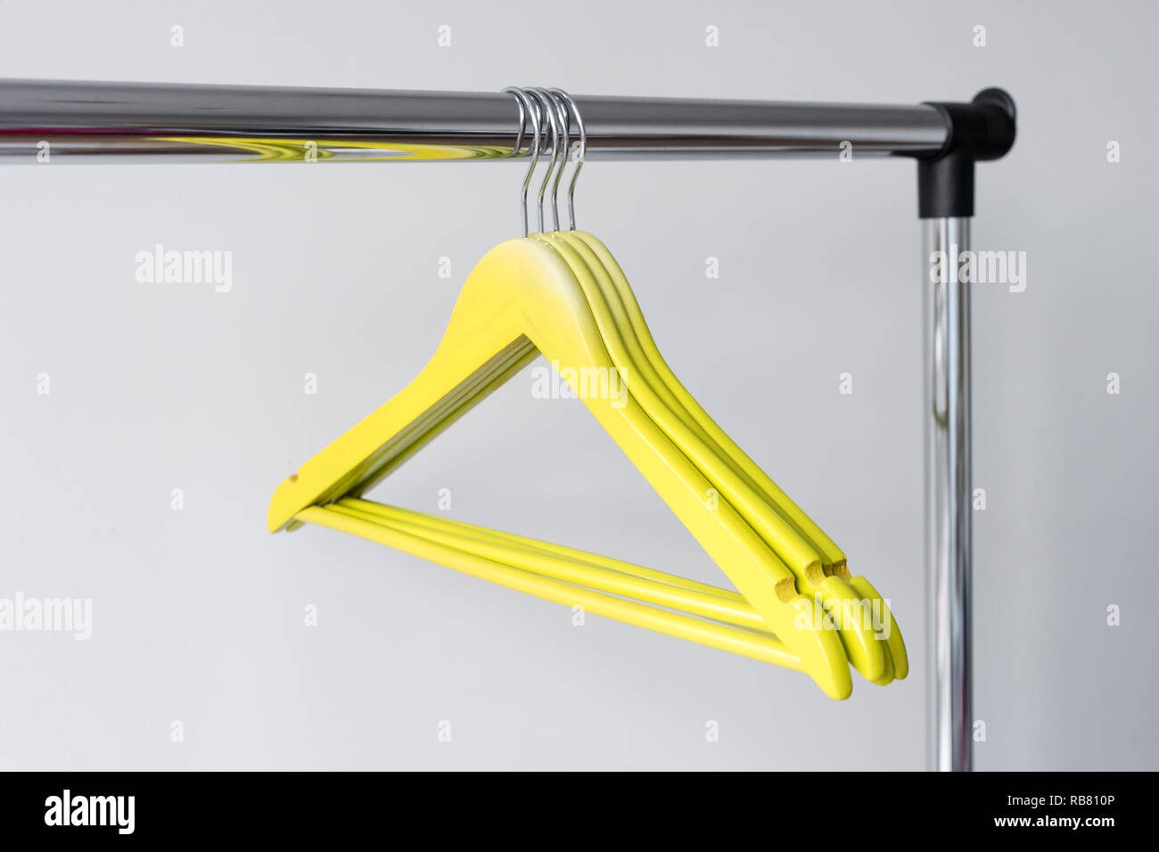 Empty clothes hangers on metal rail against grey background ...