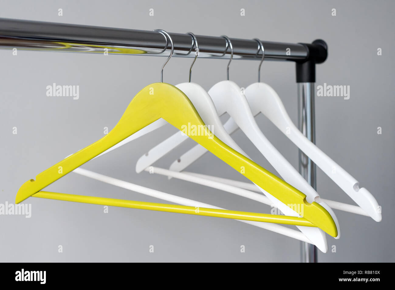 Empty clothes hangers on metal rail against grey background ...
