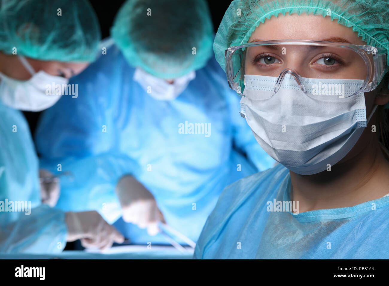 Closeup of surgeons performing operation. Focus on female nurse ...