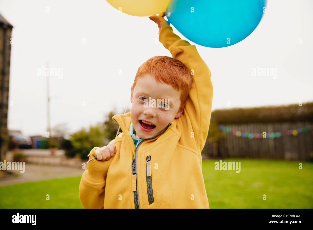 Headshot of a little boy looking at the camera while holding two yellow ...