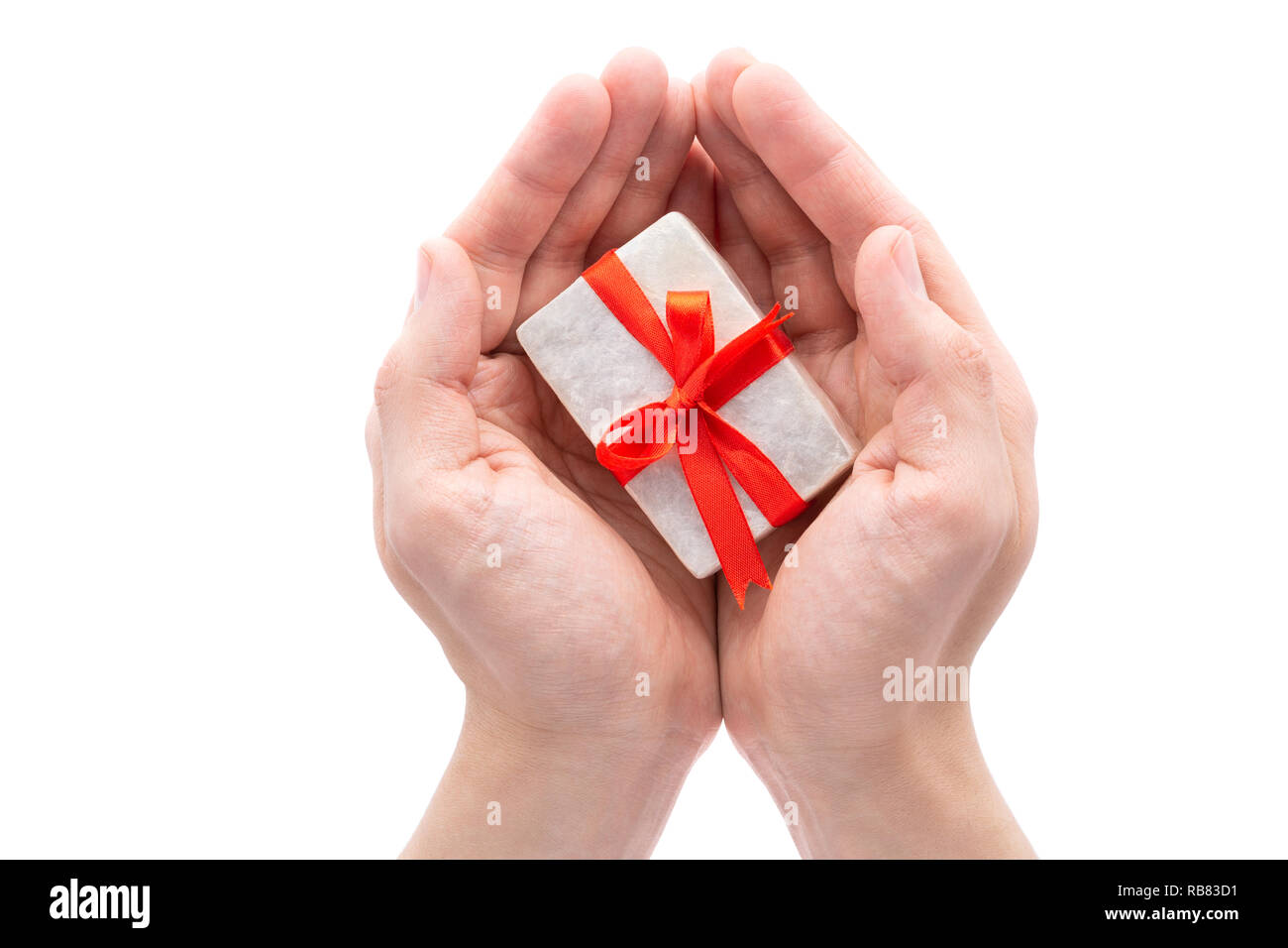 Hands holding little gift with red bow. Isolated Stock Photo - Alamy