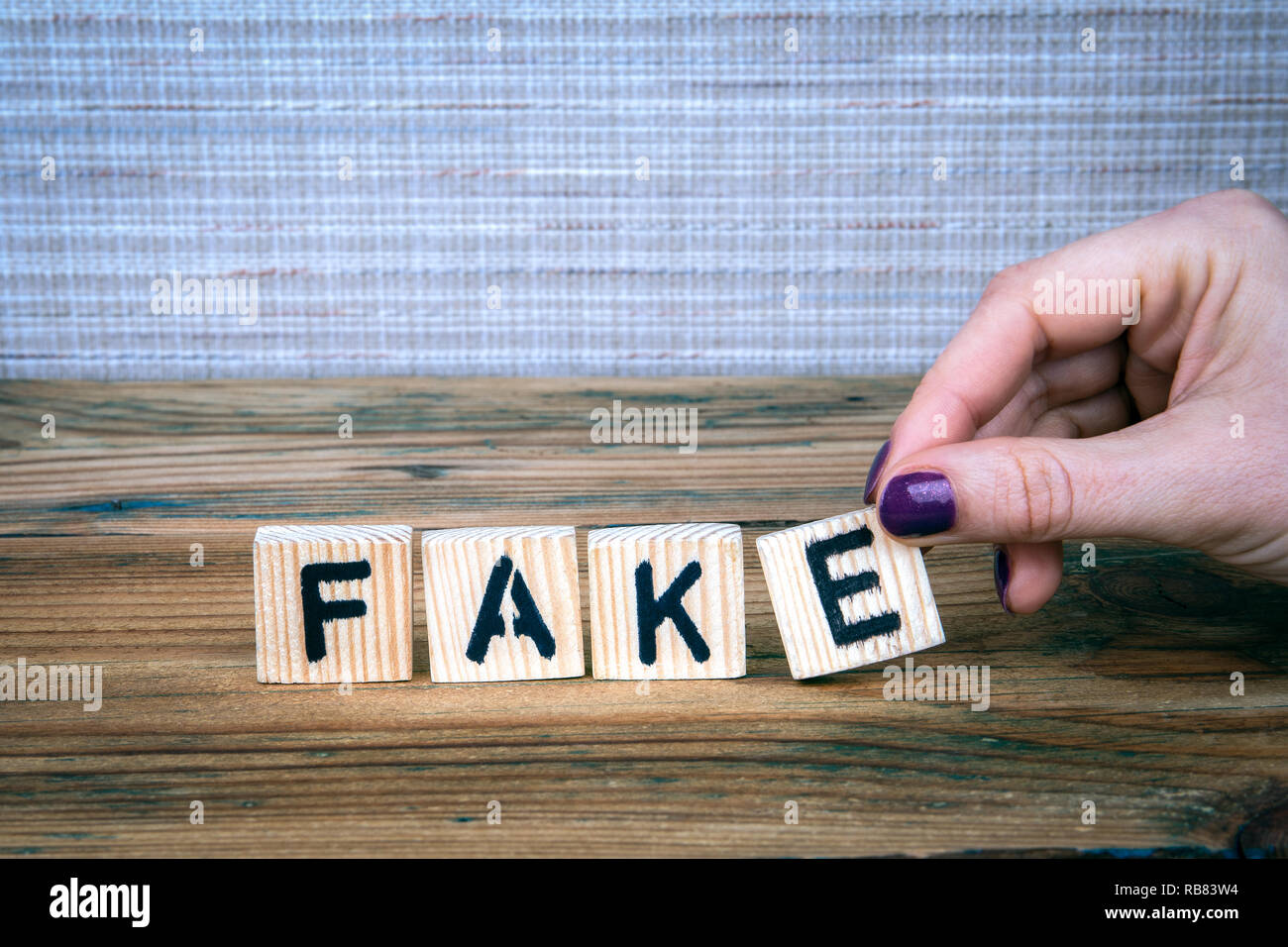 Fake. Wooden letters on the office desk Stock Photo - Alamy