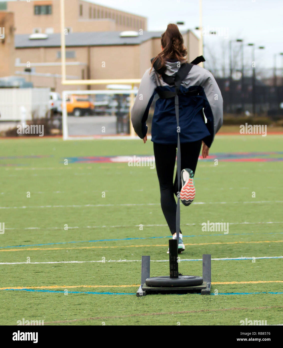 A high school girls pulls a weighted sled during track practice Stock ...