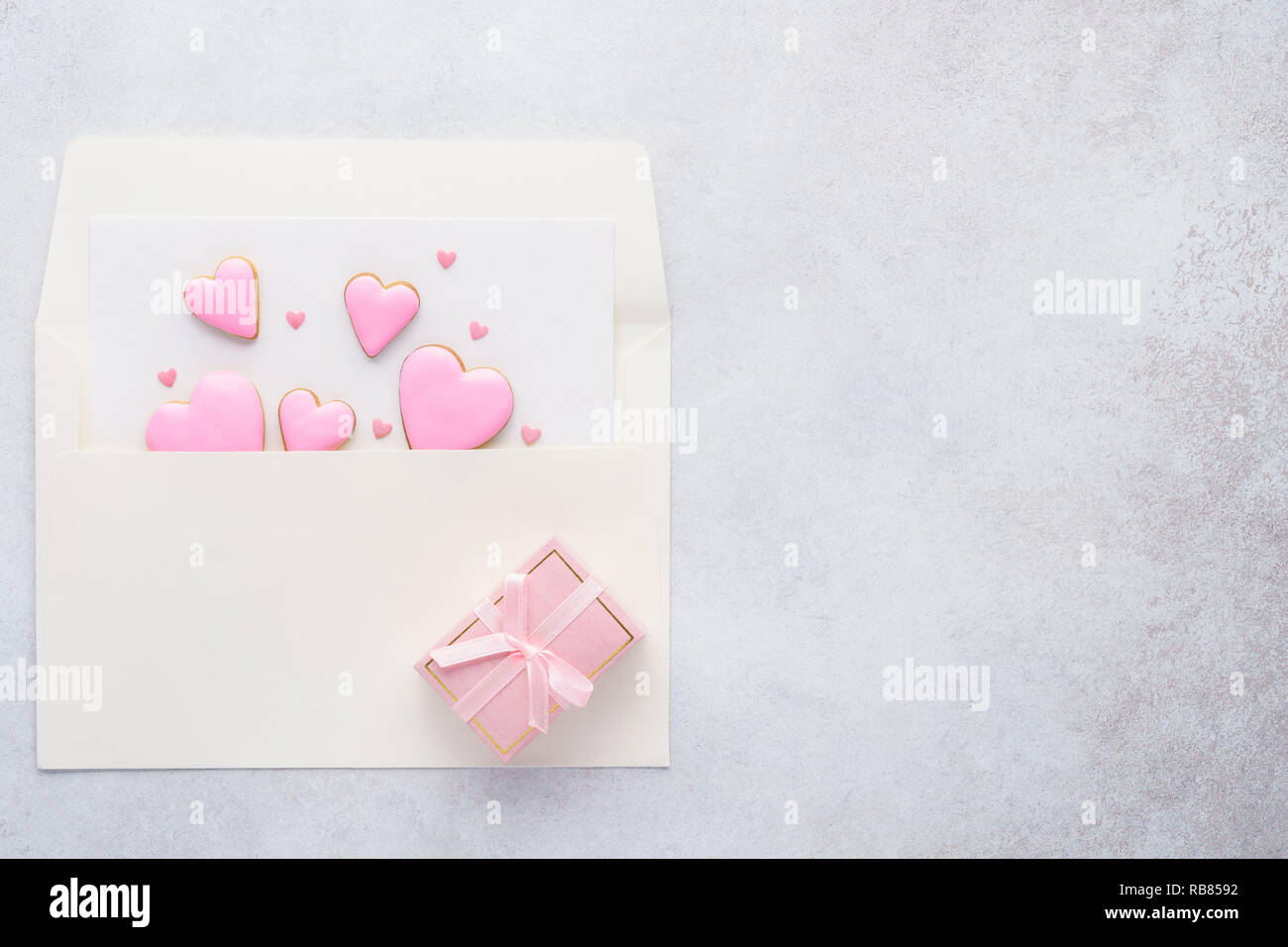 Pink heart shaped cookies in an envelope and a gift box. Valentine's ...