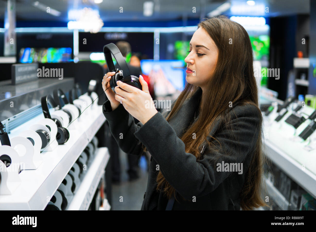 beautiful woman testing headphones in modern store Stock Photo - Alamy