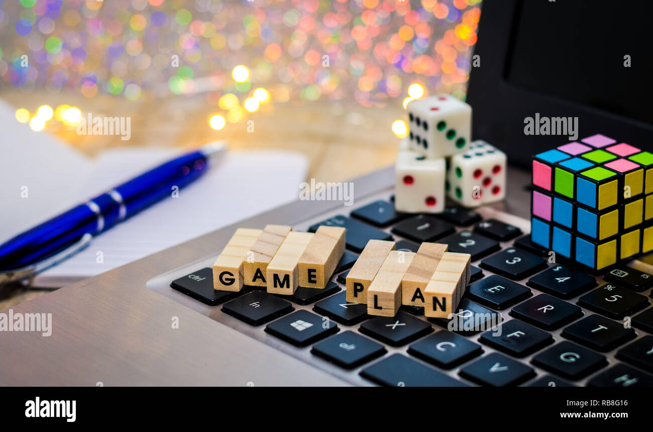 Game Plan still life concept with dice on laptop and fun lights on ...