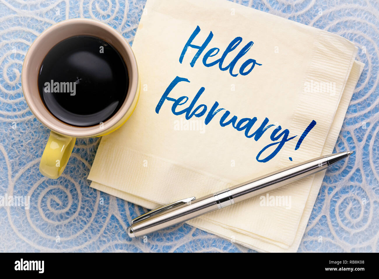 Hello February - handwriting on a napkin with a cup of coffee against ...