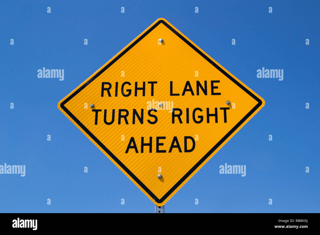 The "Right lane turns right ahead" street sign with California blue ...