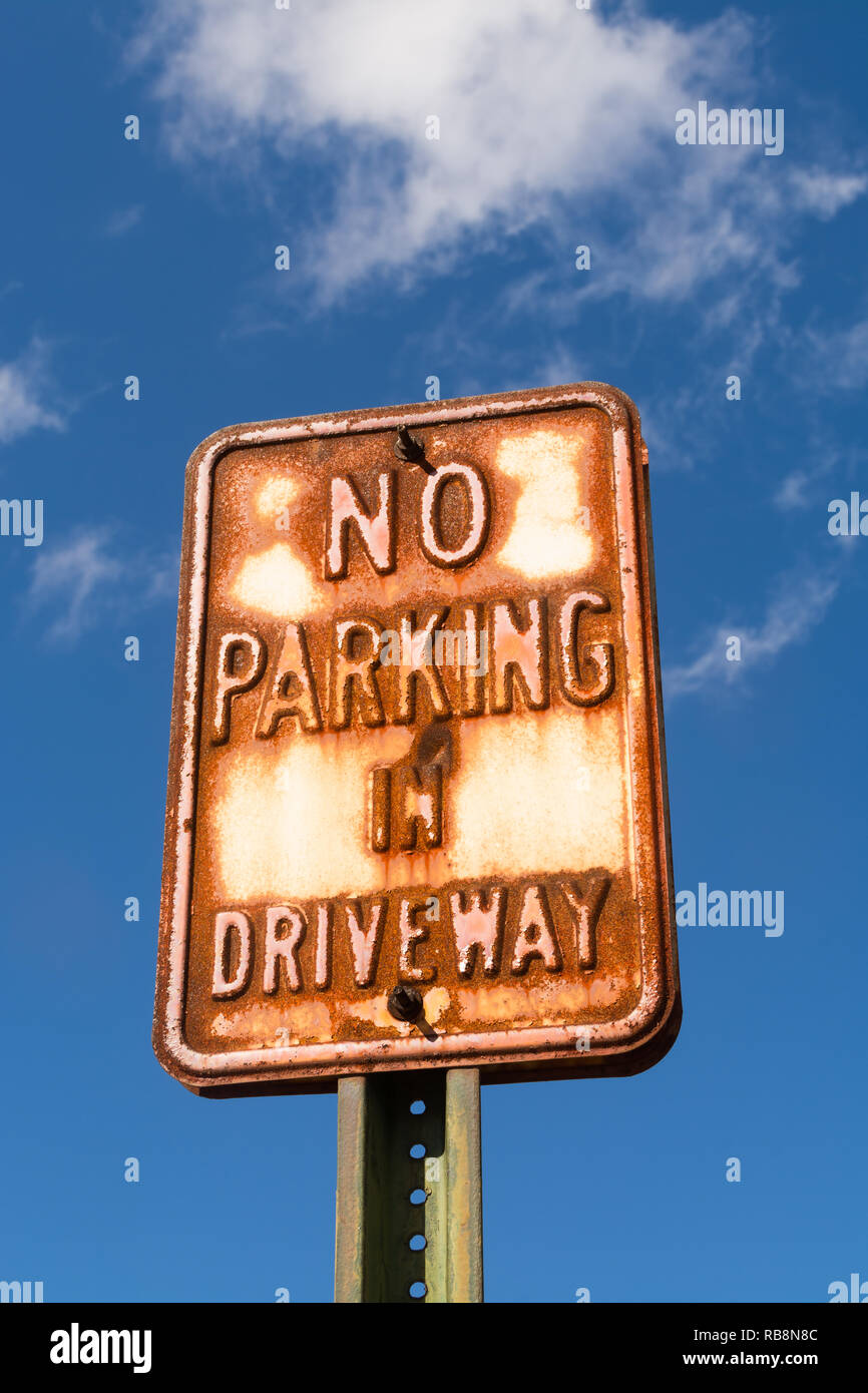 Rusty "No Parking in Driveway" street sign in the afternoon light Stock ...