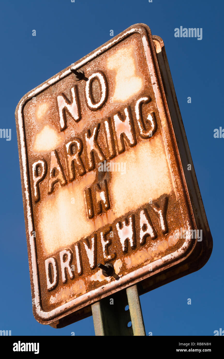 Rusty "No Parking in Driveway" street sign in the afternoon light Stock ...