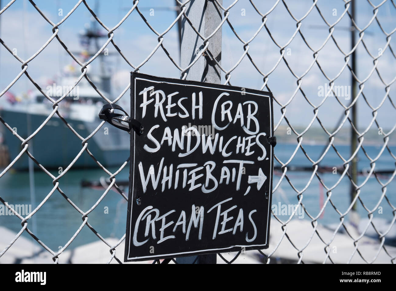 Crab sandwiches sign with warship in the background Stock Photo - Alamy