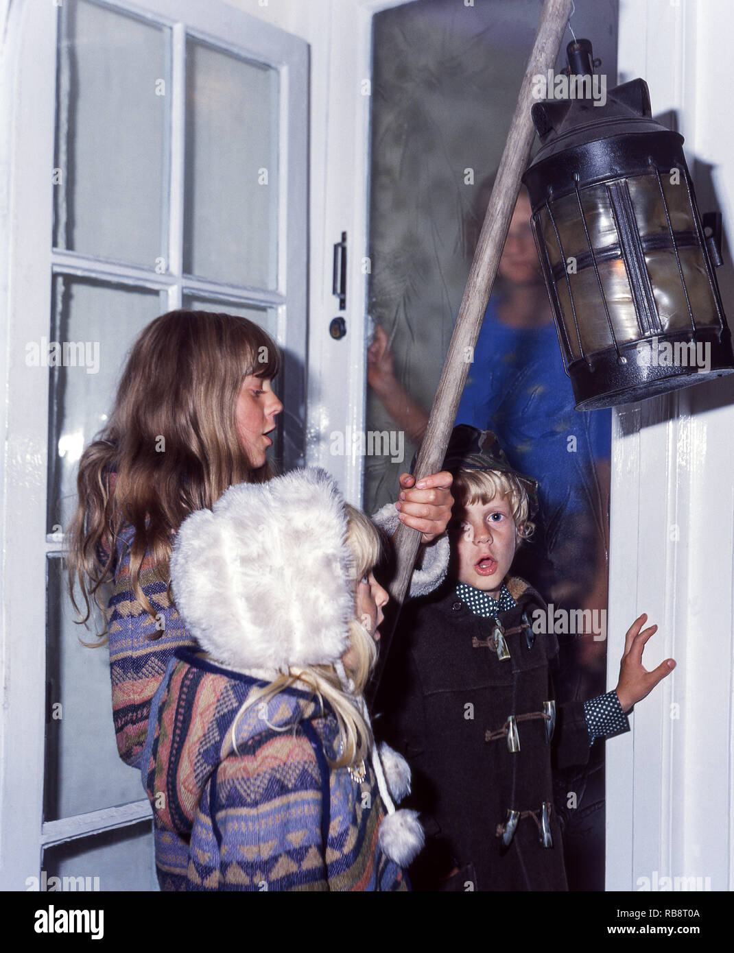 3 children carol singing outside a front door Stock Photo - Alamy