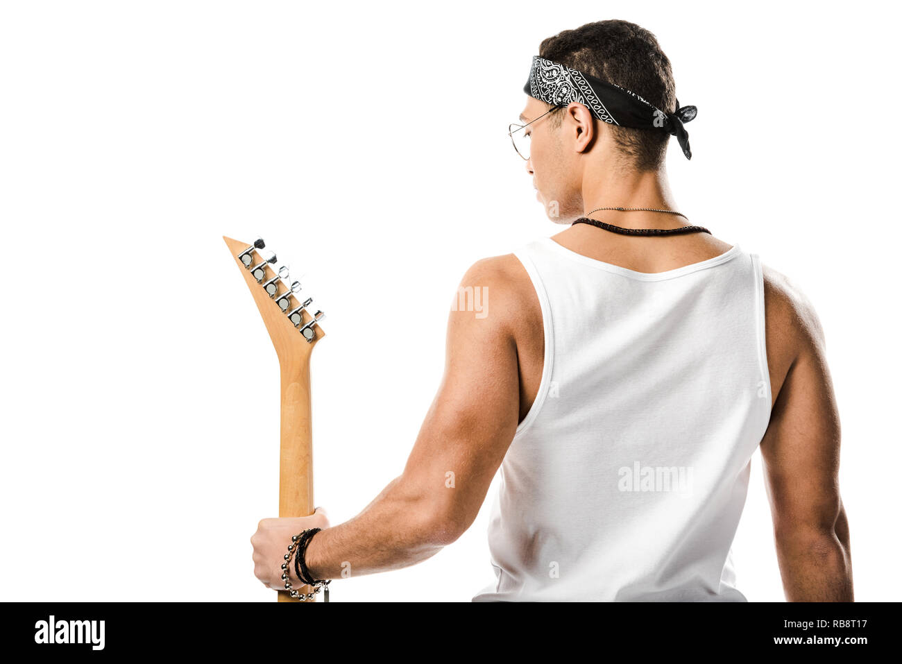 rear view of young male rock musician posing with black electric guitar ...