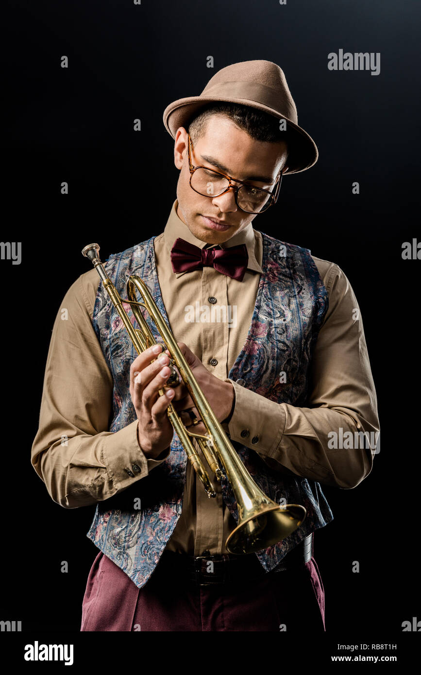 mixed race male musician posing with trumpet isolated on black Stock ...