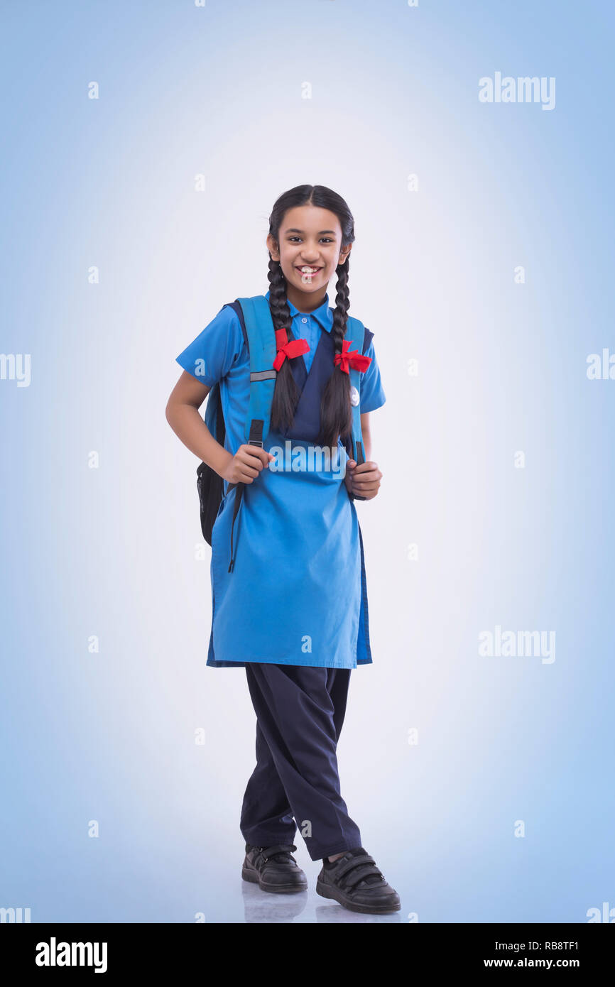 Portrait of school girl in uniform holding book and bag Stock Photo - Alamy