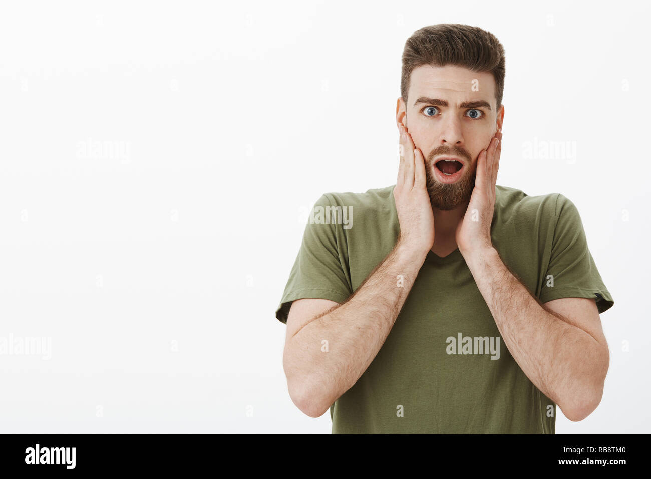 Studio shot of shocked man learning terrible news or rumors spreading ...