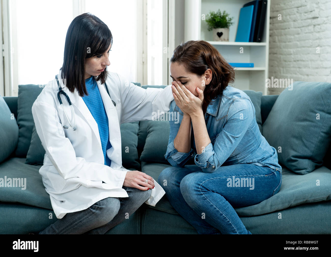Female doctor comforting depressed crying woman patient sitting ...